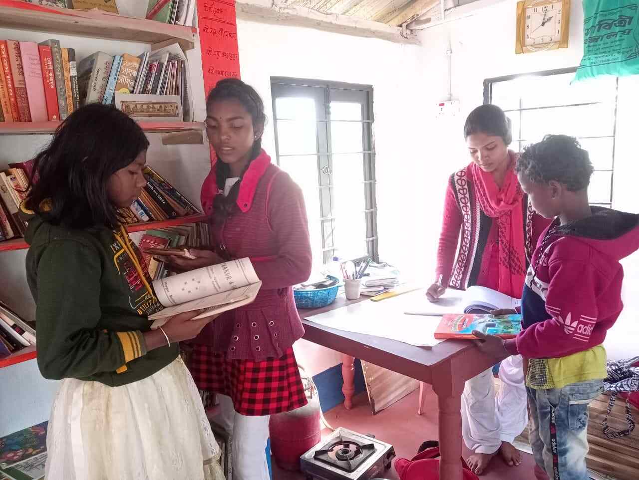 Village students checking out books in the library - The CSR Journal